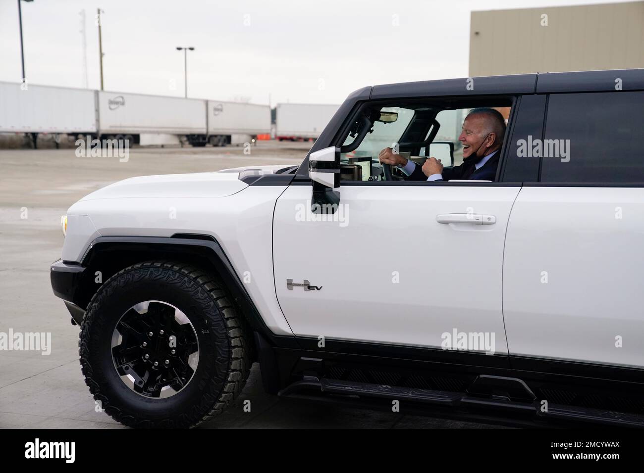 President Joe Biden smiles as he test drives a Hummer during a tour of ...