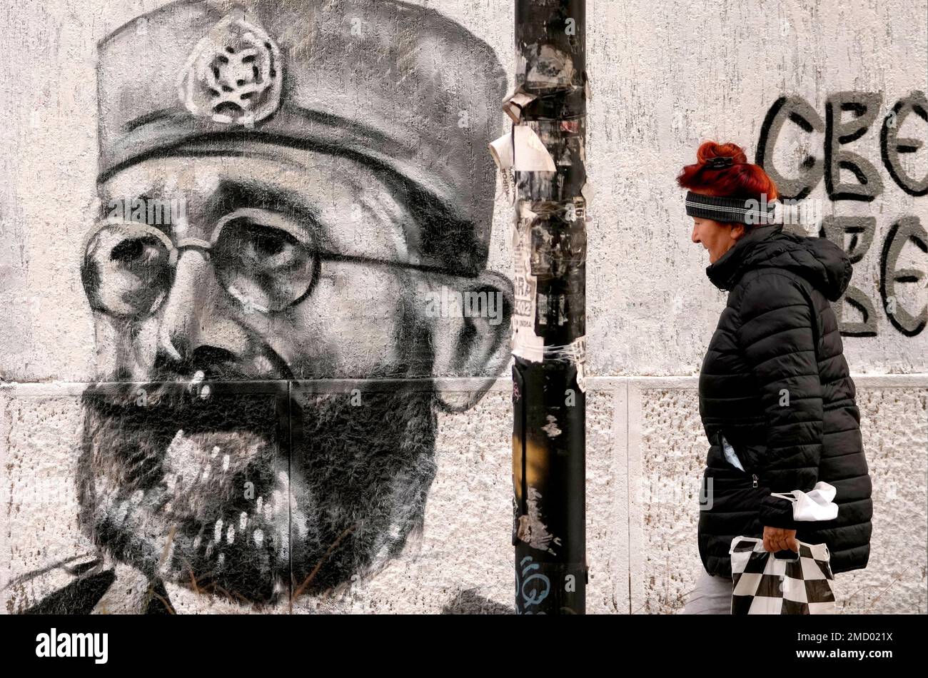 A woman walks by a newly draw mural of controversial Serb World War II ...