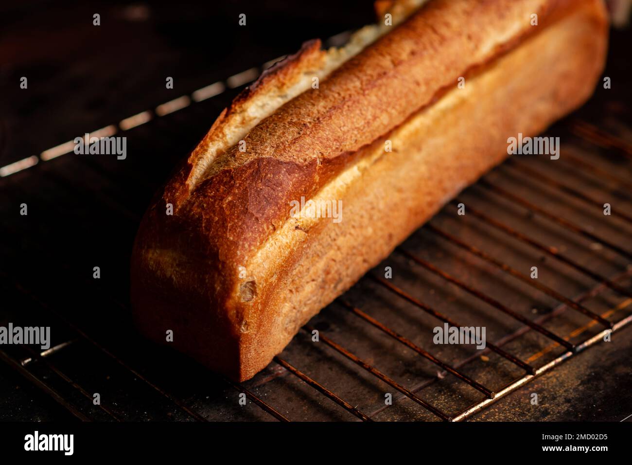 A loaf of French bread in an oblong shape on a dark background Stock ...
