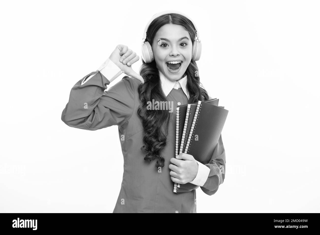 Student girl in headphones holding books. Education in school or ...