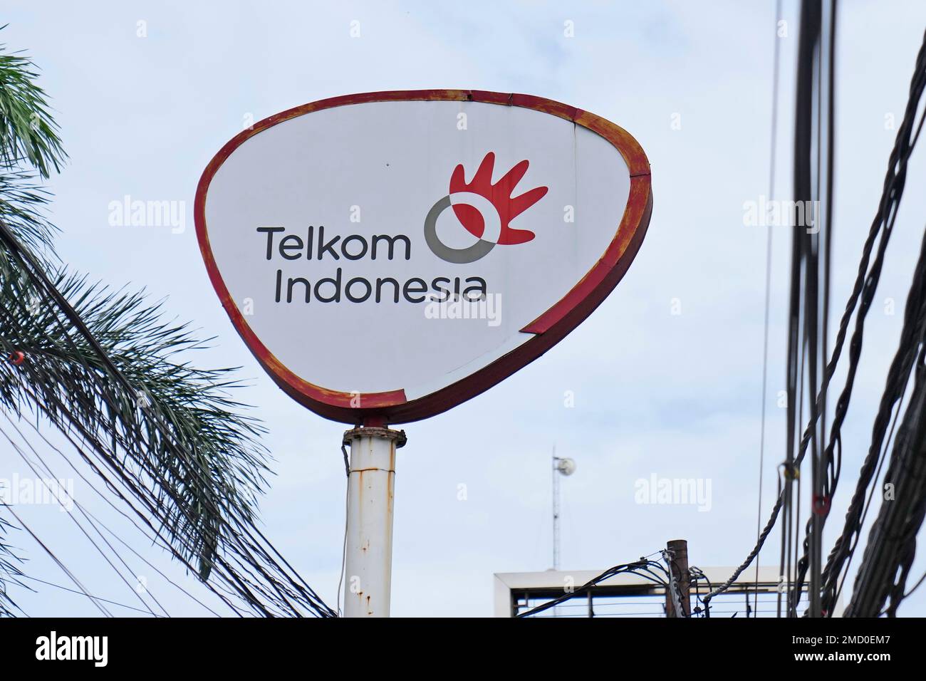 A Telkom Indonesia logo is displayed on a sign outside one of its ...
