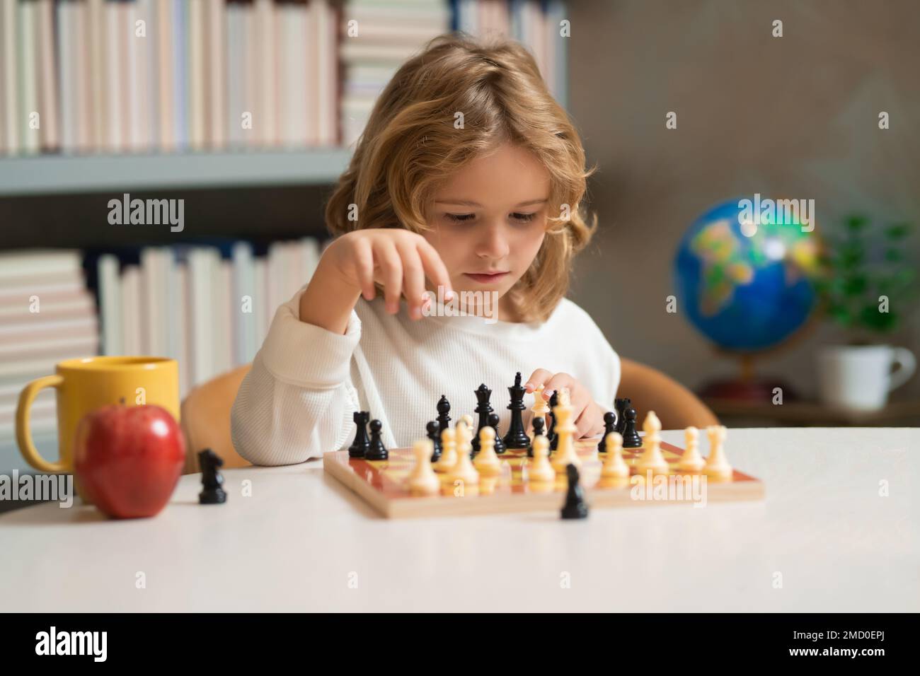 Clever concentrated and thinking child playing chess. Logic game for ...