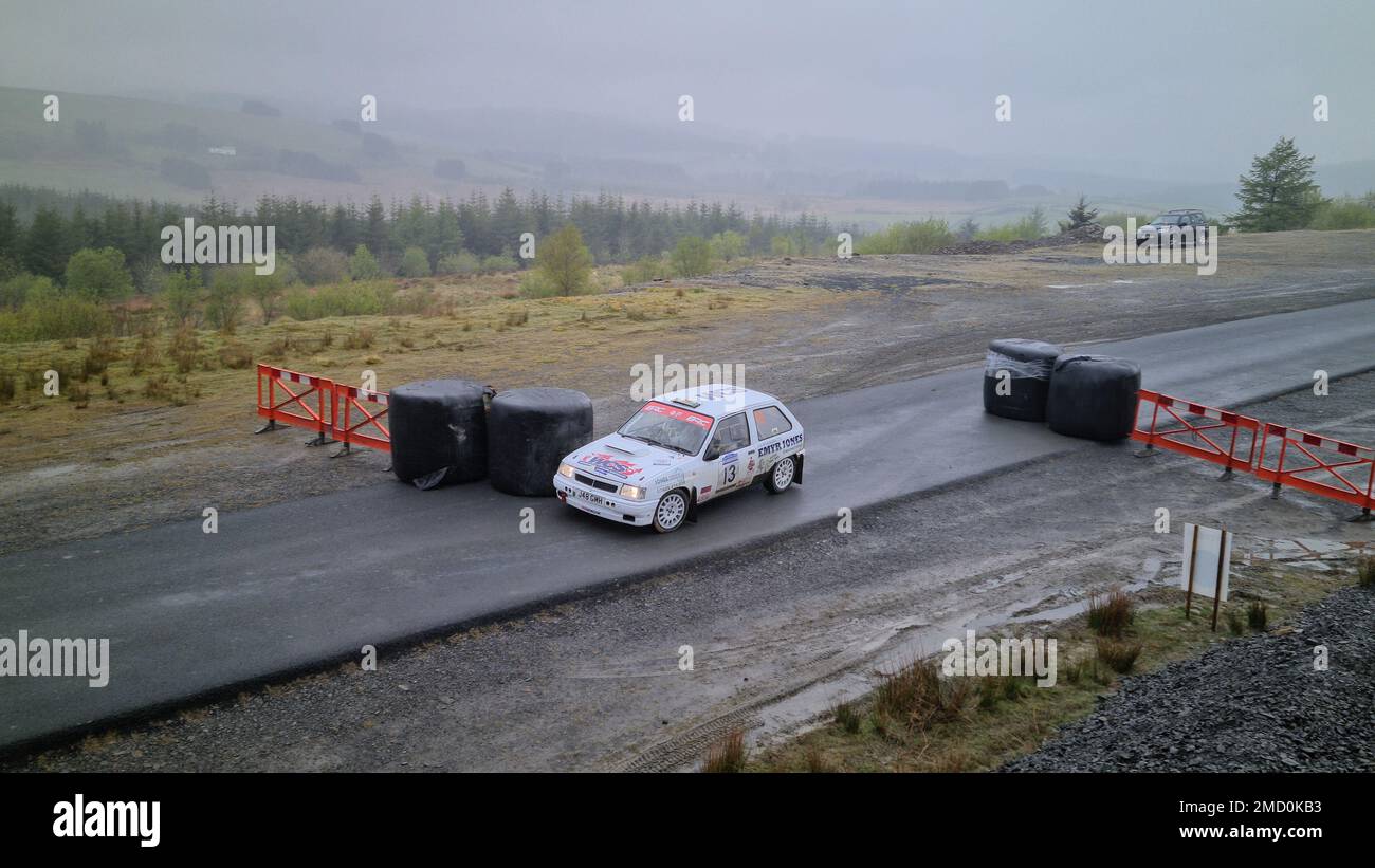 A high angle closeup shot of a white race car on a track on a rainy day ...