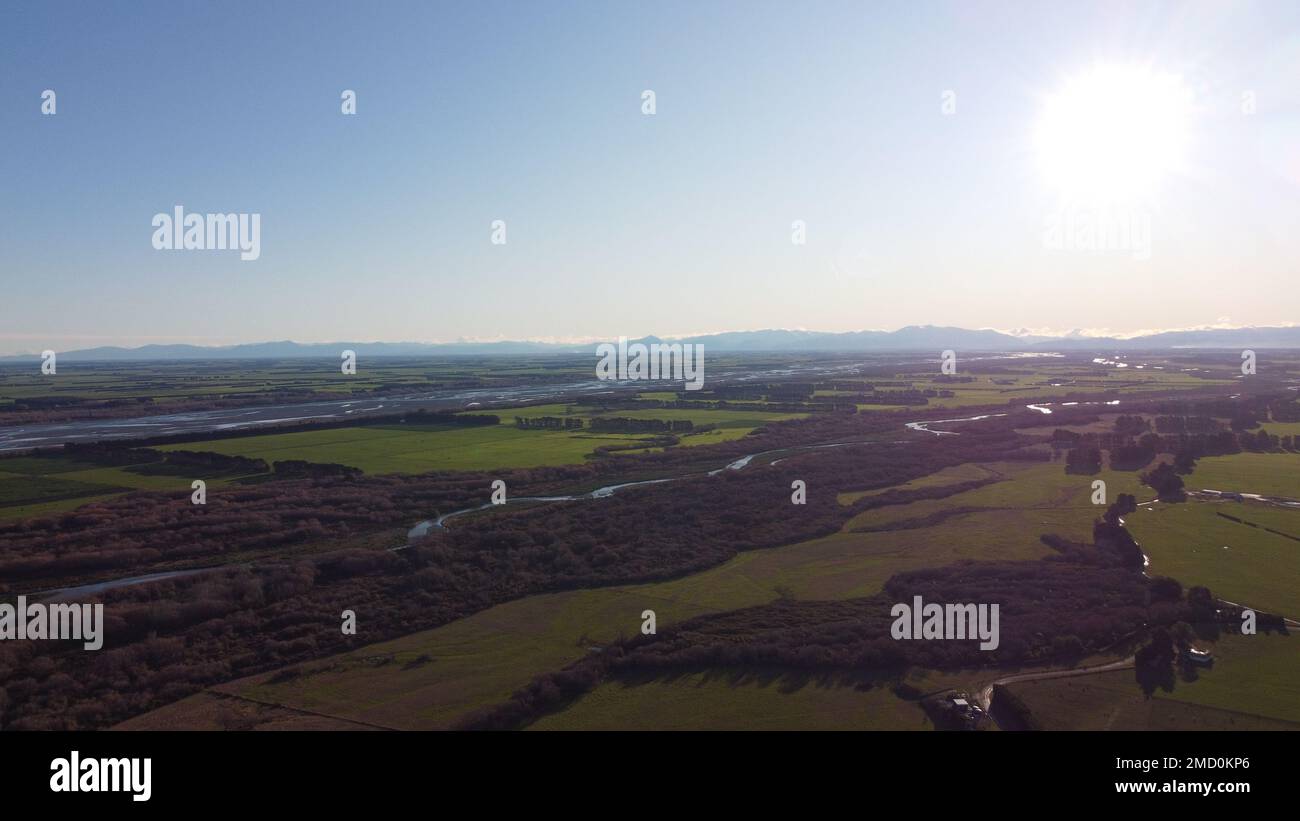 An aerial landscape view of a green grass field with a river passing ...