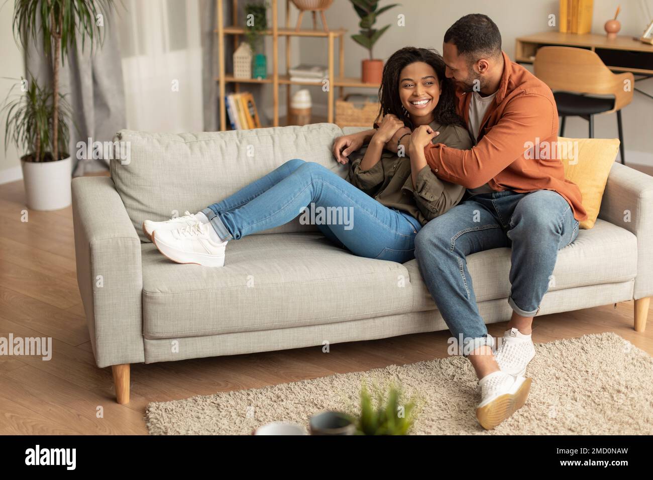 Romantic african american couple relaxing on couch at home, bonding and ...