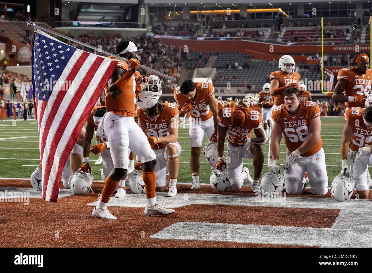Texas defensive back D'Shawn Jamison (5) carries the American flag ...