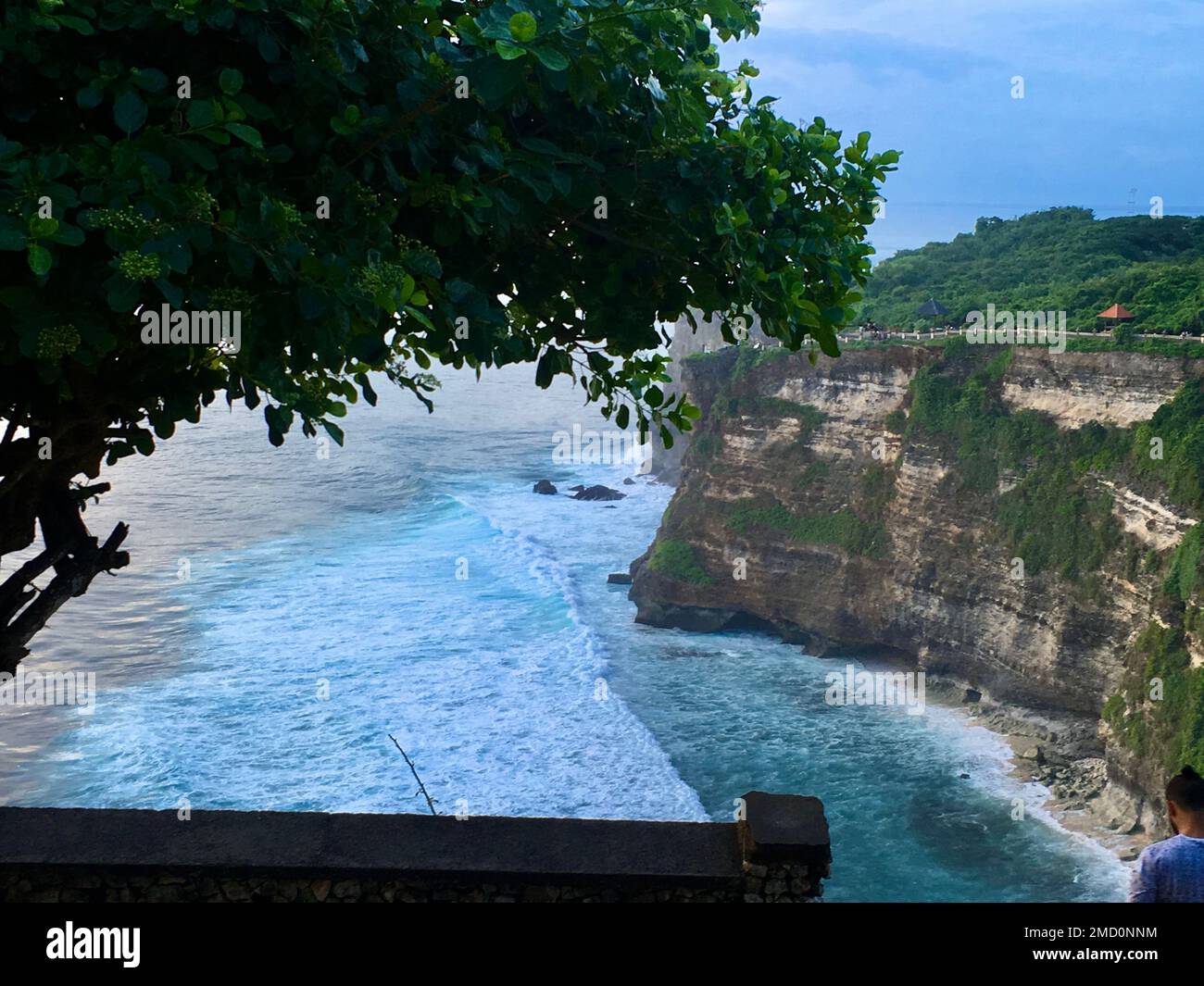 A beautiful view of a wave sea next to a hill with green mountains in ...