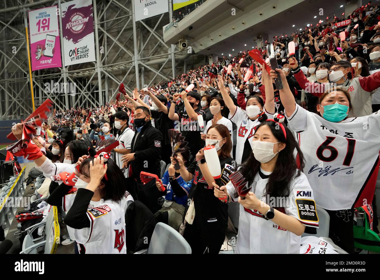Fans wearing face masks as a precaution against the coronavirus cheer ...