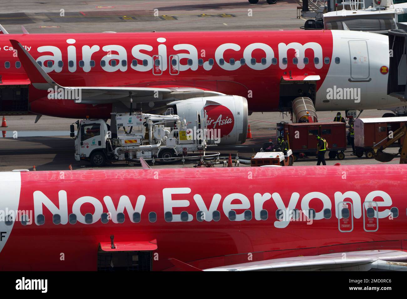 Ground staff refill Air Asia planes Airbus A320 parked at tarmac at ...