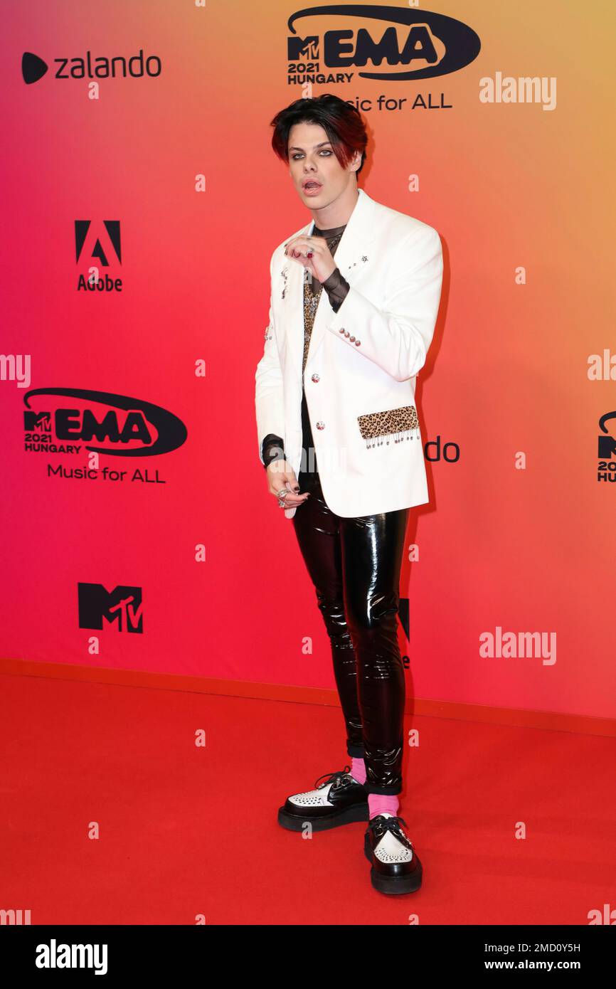 Yungblud poses for photographers whilst wearing a jacket with the ...