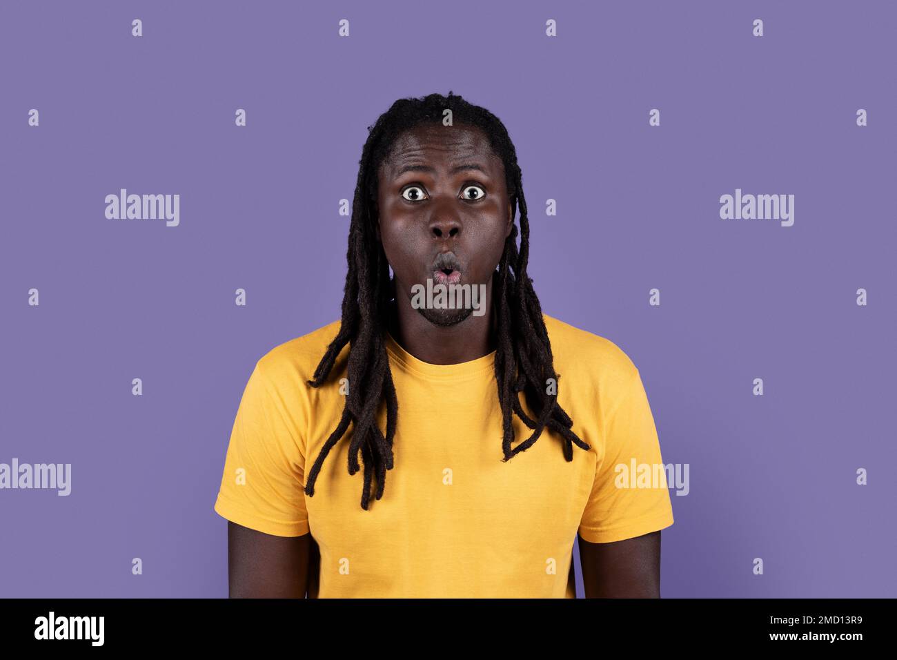 Portrait of astonished black guy posing on purple Stock Photo - Alamy