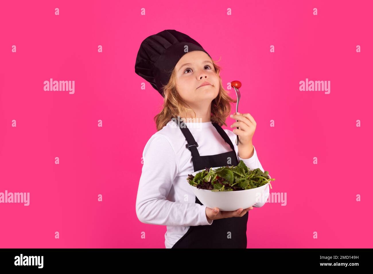 Kid cook hold plate with vegetables and fork with tomato. Cooking ...