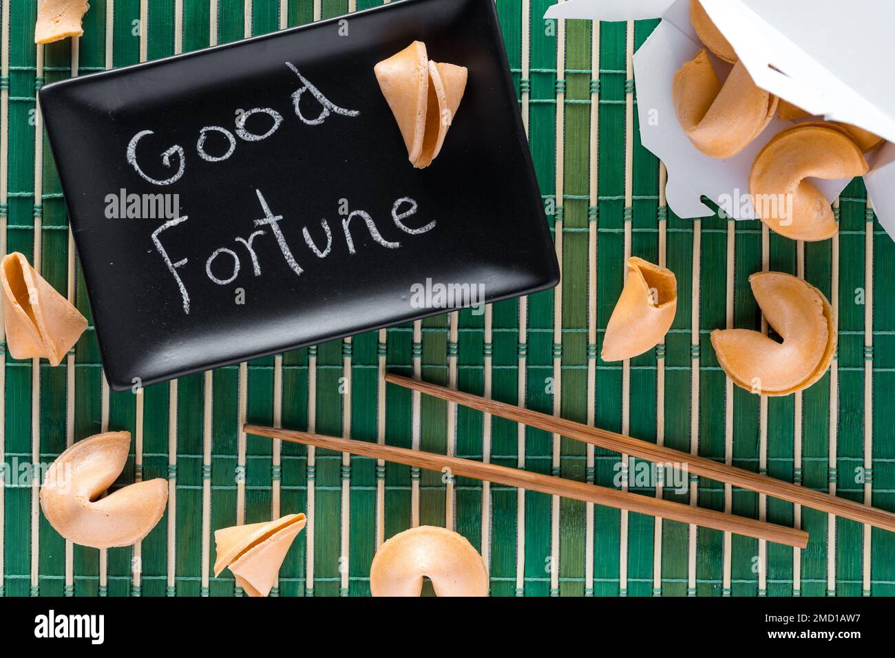 Fortune cookies on a bamboo mat with chopsticks and a note on a sushi ...