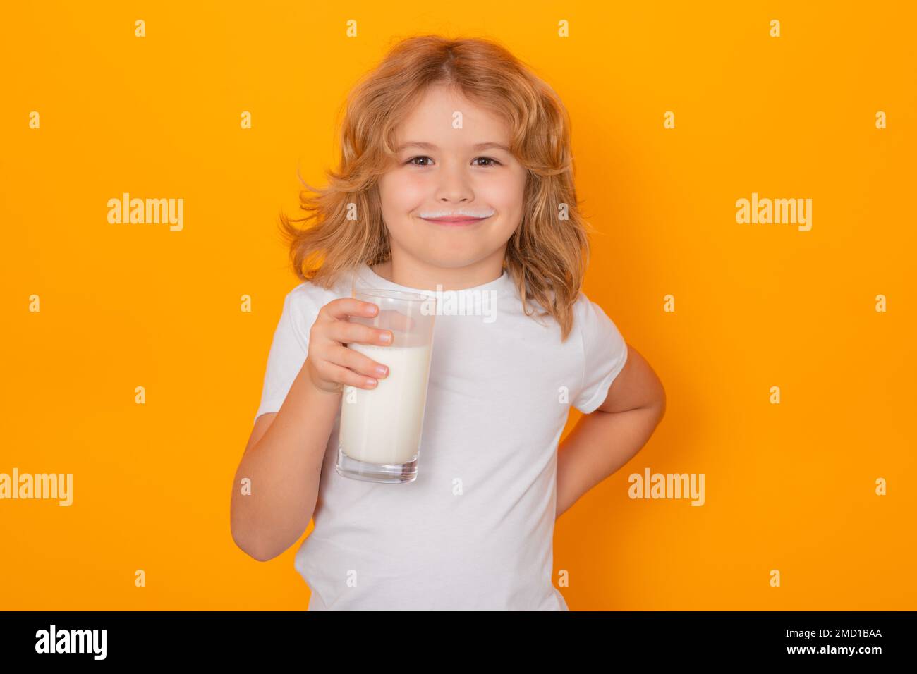 Child with glass of milk on studio yellow background. Kid with milk ...