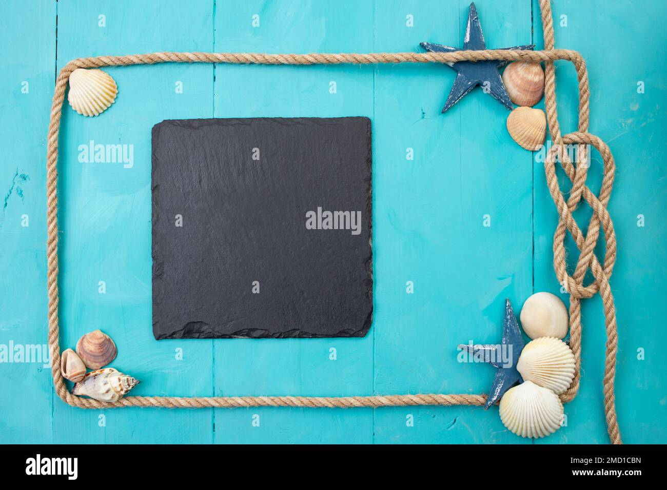 Jute rope frame with a knot, sea shells, stars and a square black stone ...