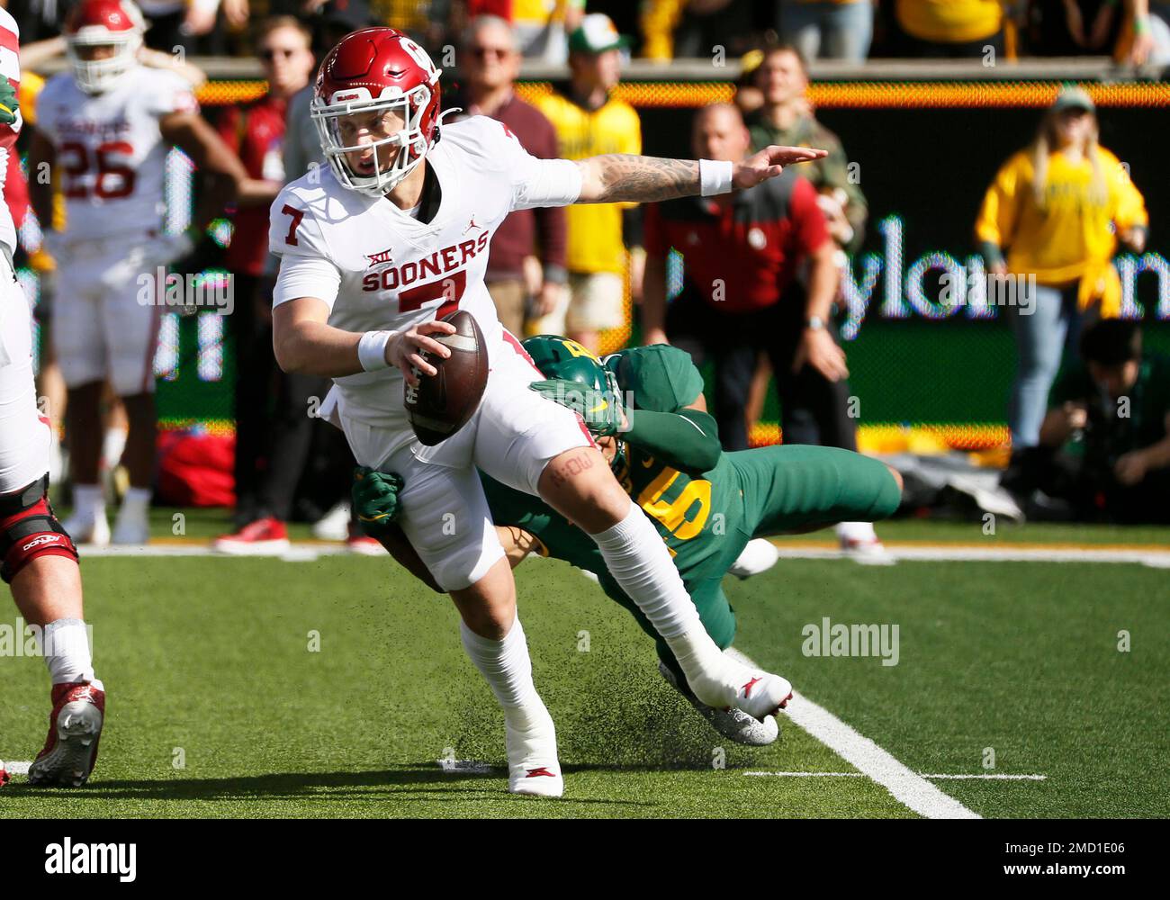 Oklahoma quarterback Spencer Rattler, left, avoids the tackle by Baylor ...
