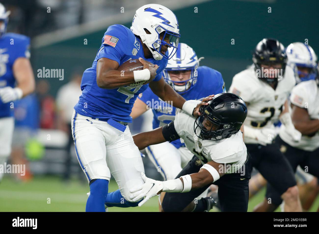 Air Force quarterback Haaziq Daniels (4) stiff arms Army linebacker ...