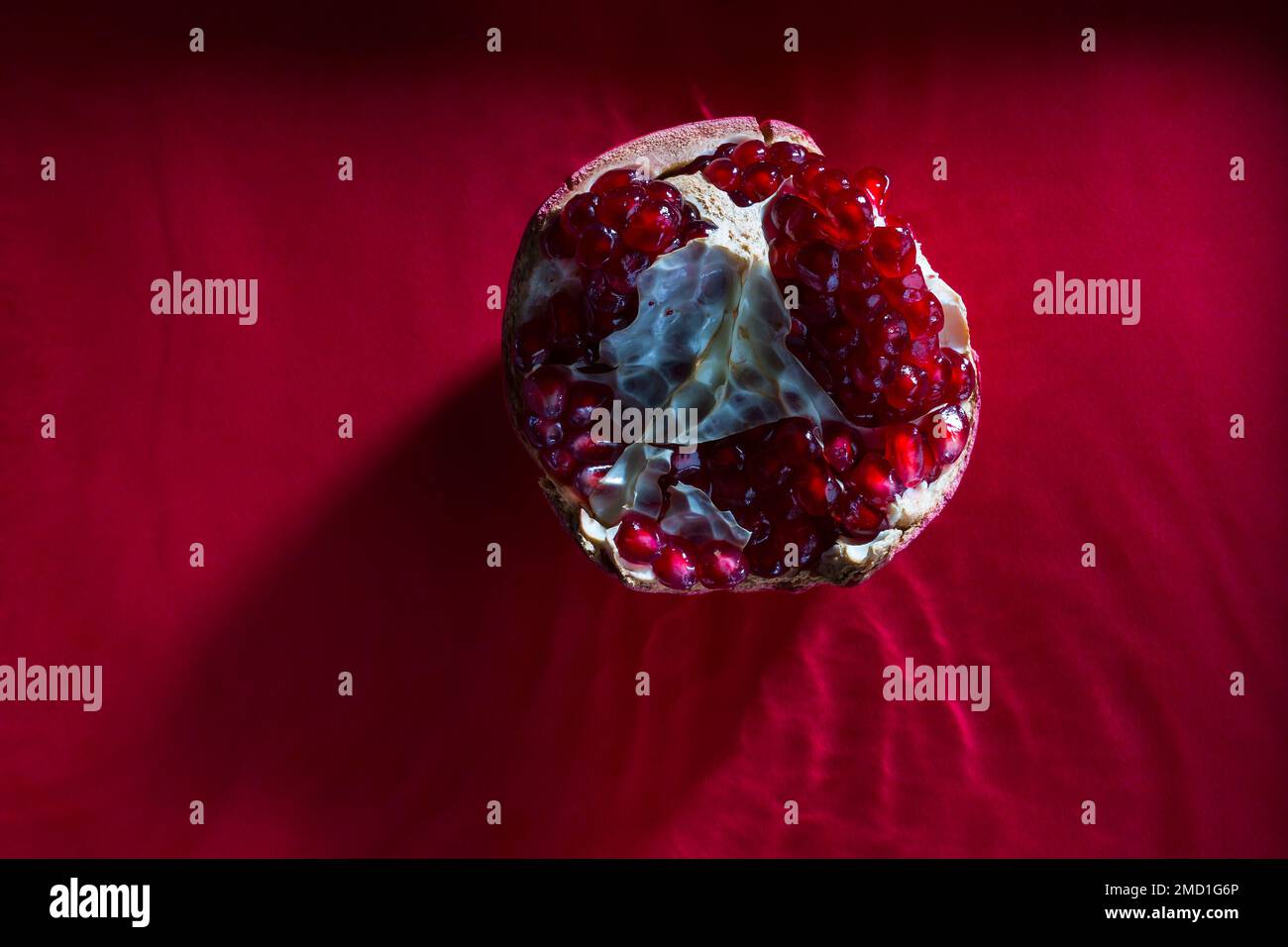 Red pomegranate fruit on magenta color background Stock Photo - Alamy