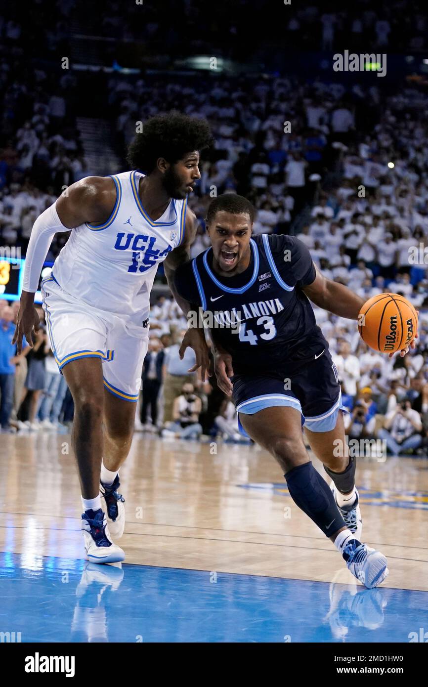 Villanova forward Eric Dixon, right, dribbles past UCLA center Myles ...