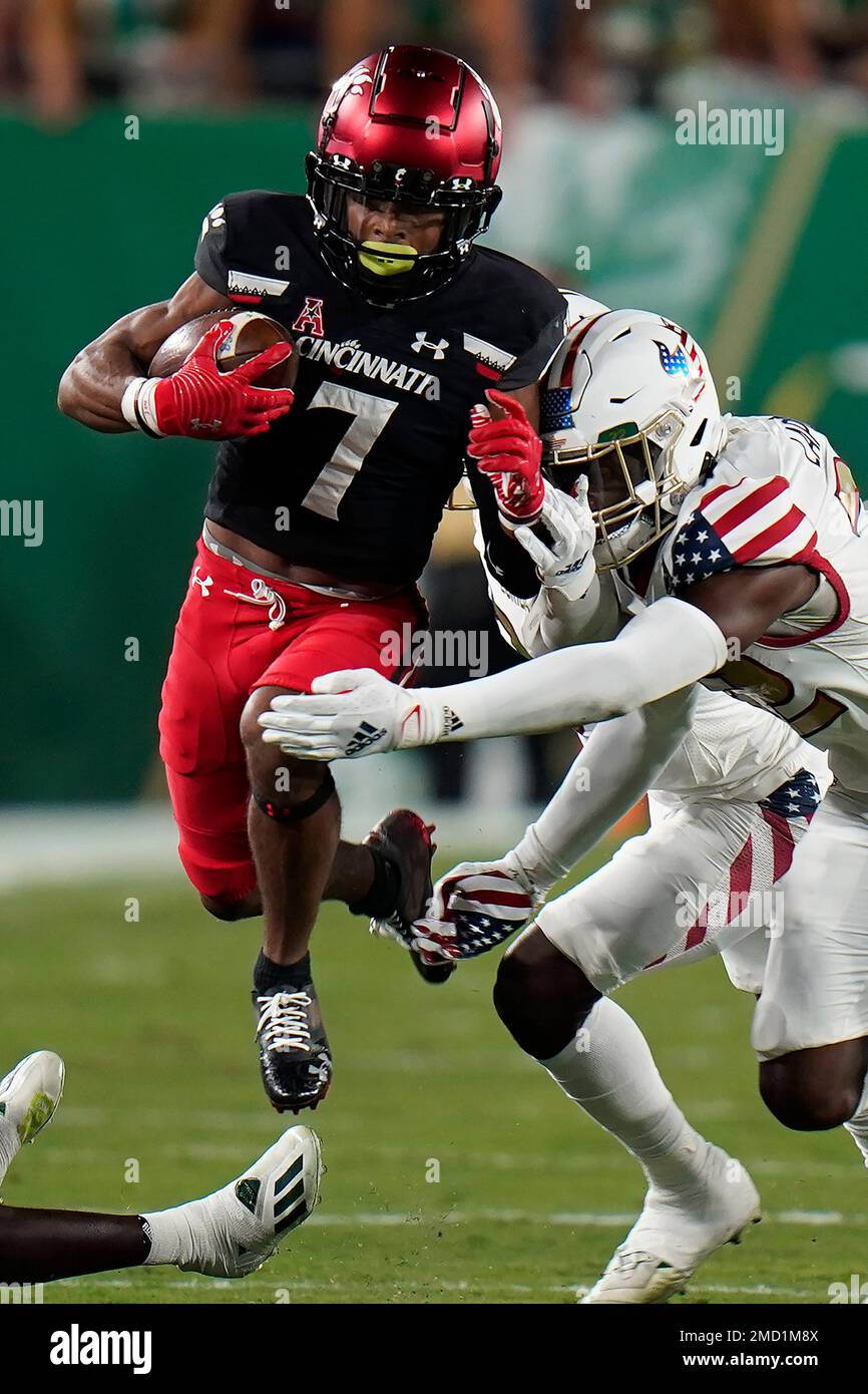 Cincinnati wide receiver Tre Tucker (7) leaps away from a tackle by ...