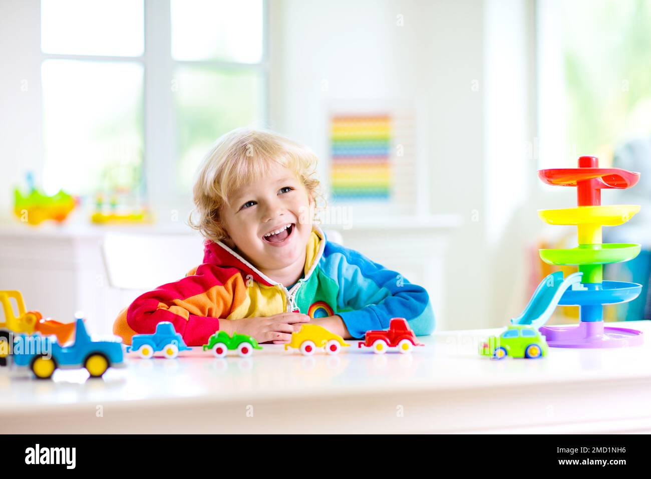 Little boy playing toy cars. Young kid with colorful educational ...