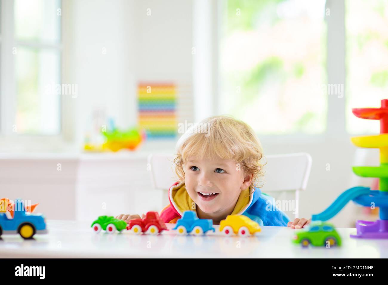 Little boy playing toy cars. Young kid with colorful educational ...