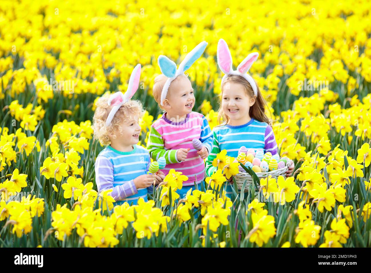 Easter egg hunt in spring garden. Kids searching for colorful eggs and ...