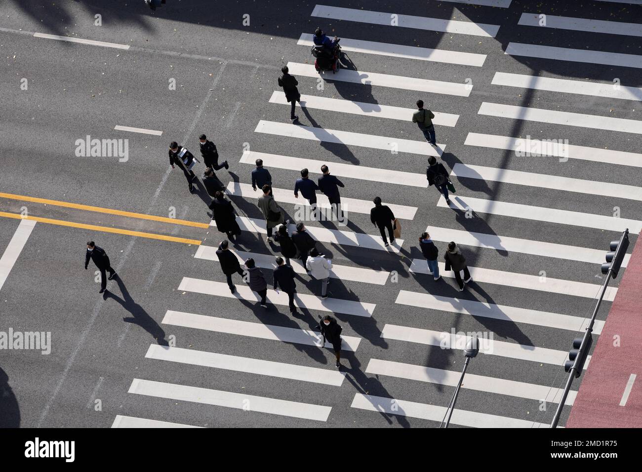 People wearing face masks walk across a pedestrian crossings in Seoul ...