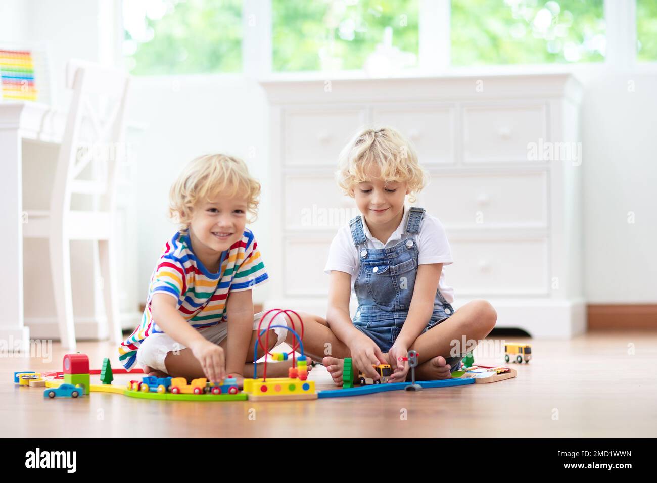 Kids play with wooden railway. Child with toy train. Educational toys ...