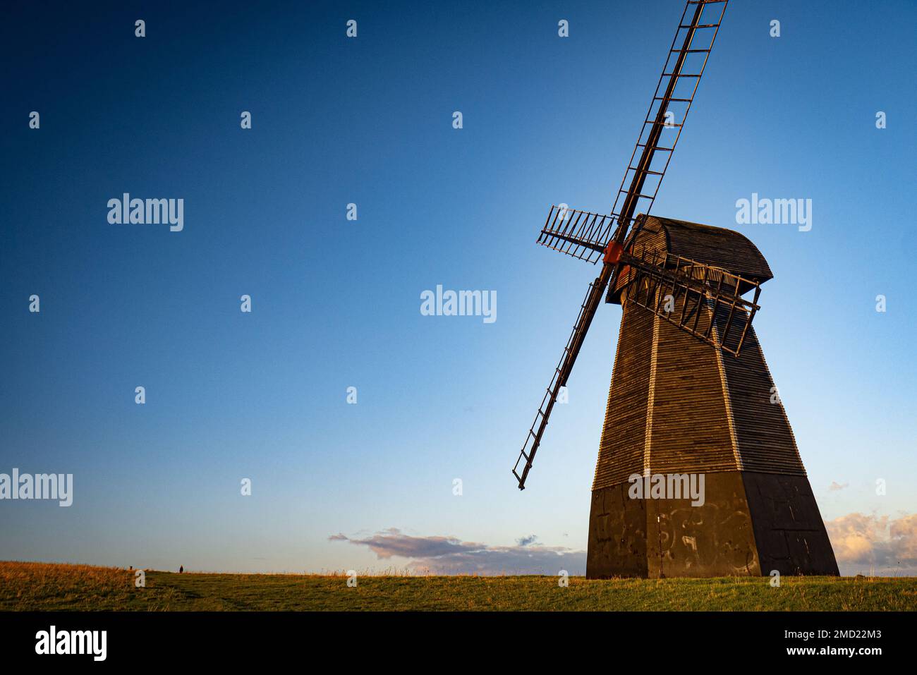A low angle shot of a windmill in the middle of a field under the ...