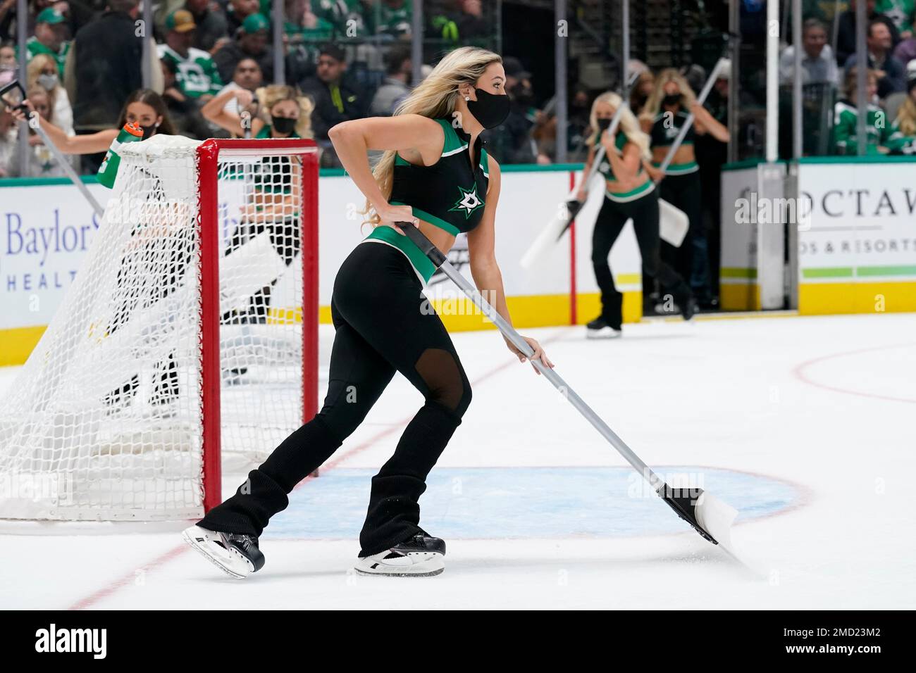 The Dallas Stars Ice Girls clear frost of the ice during an NHL hockey ...