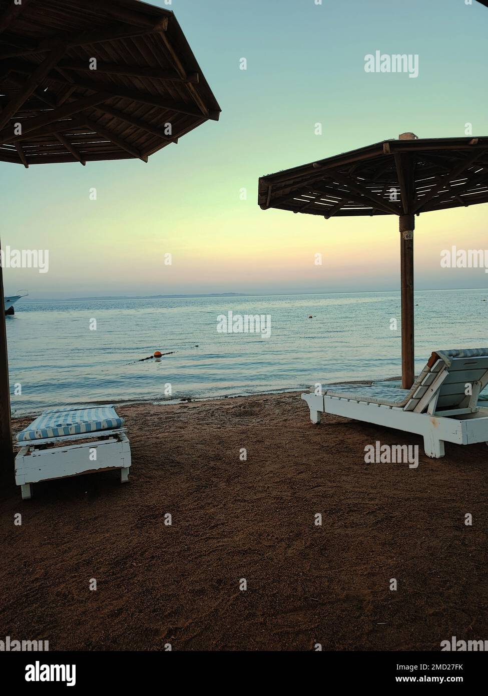 The lounge chairs by the beach on sunset Stock Photo - Alamy