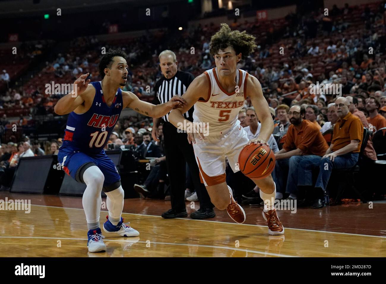 Texas guard Devin Askew (5) drives around Houston Baptist guard Jade ...