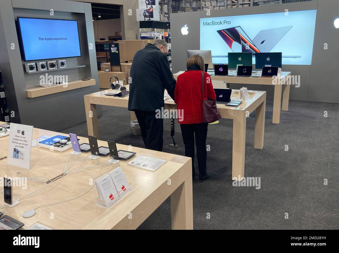 Customers look over floor models in the Apple display in a Best Buy ...