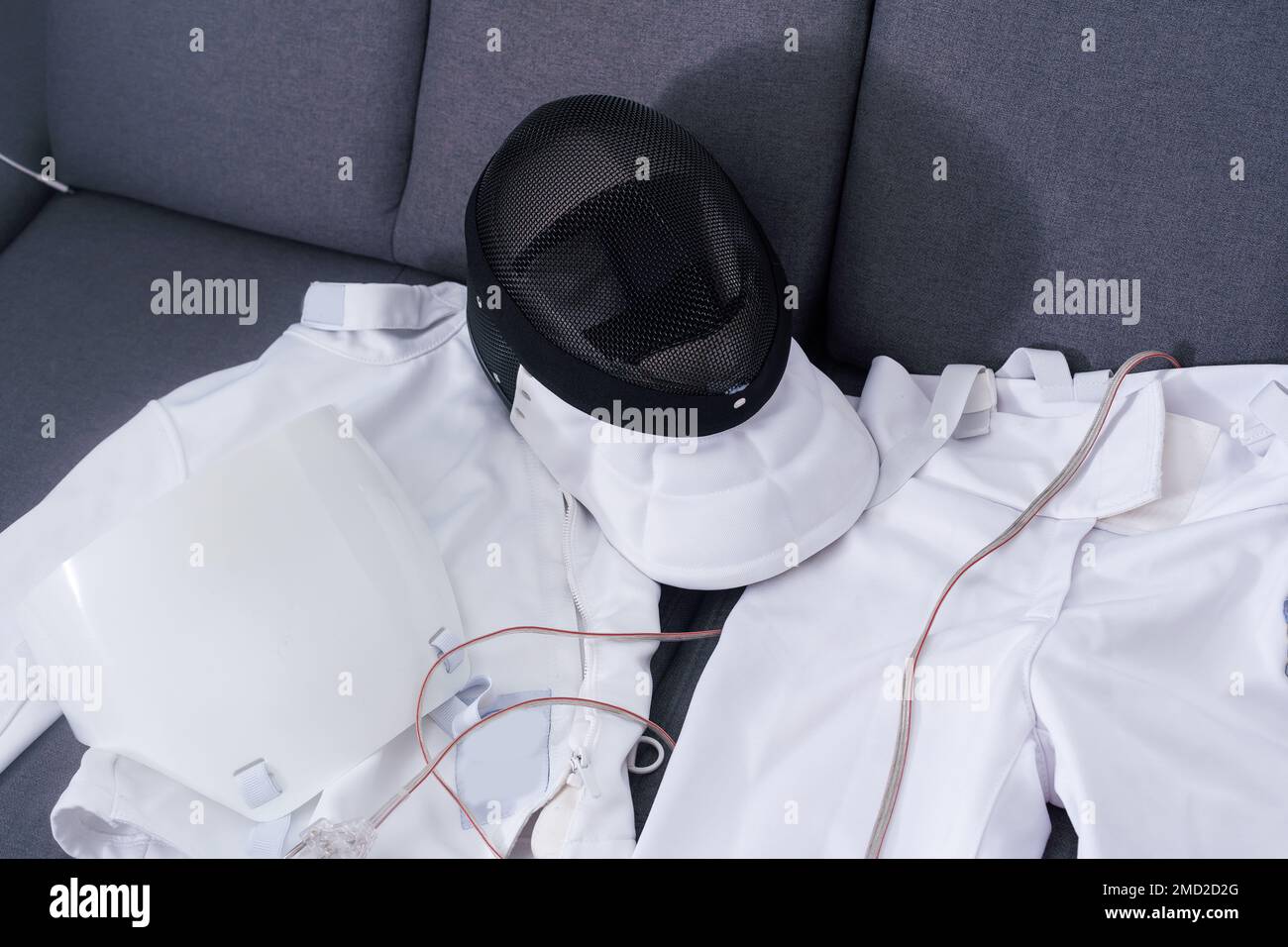 fencing mask and fencing suit on the couch Stock Photo - Alamy