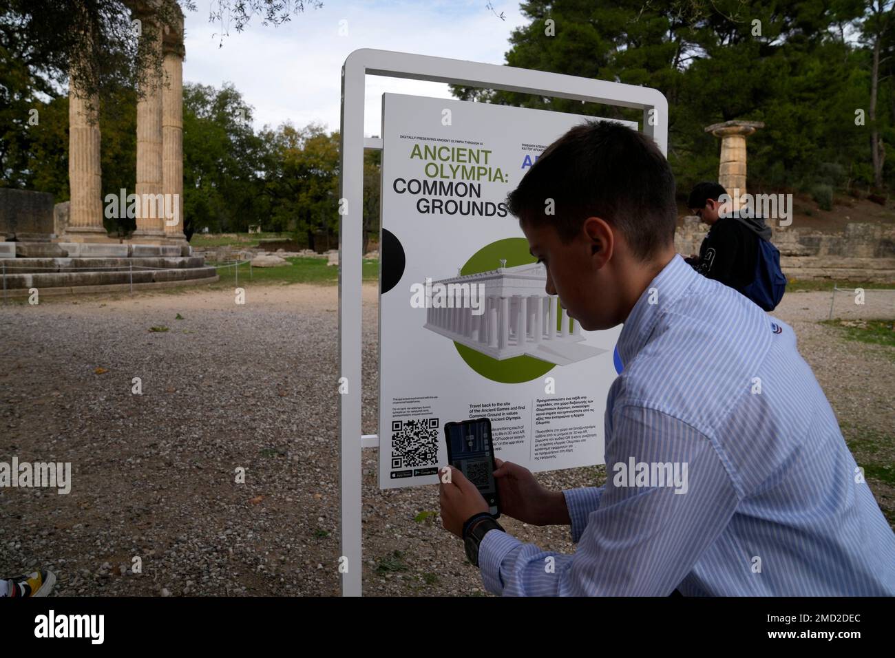 A school student scans a QR code at the ancient site of Olympia ...