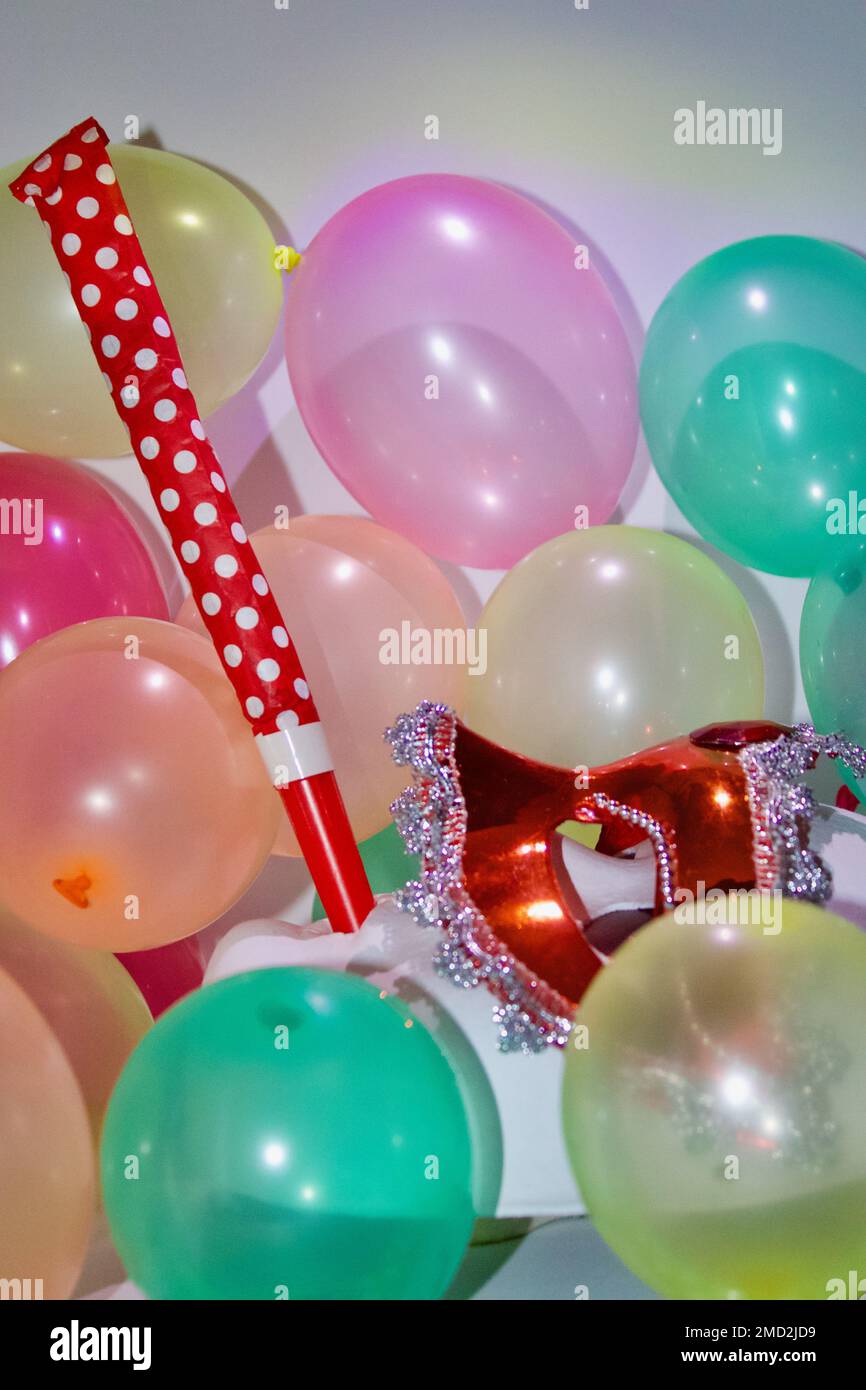 The colorful balloons, party horns and a carnival mask for birthday ...