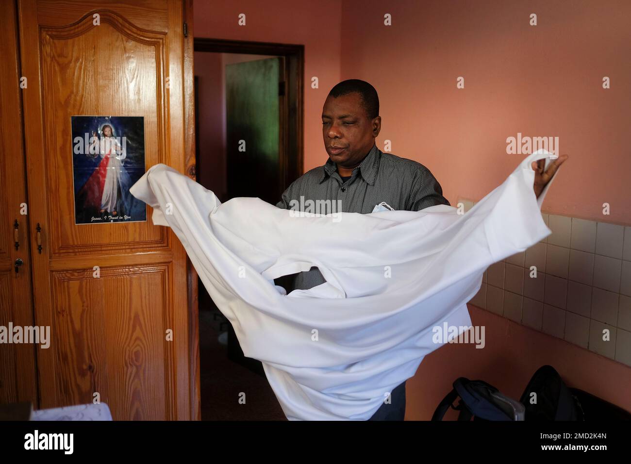 FILE - Catholic priest Jean-Nicaisse Milien changes clothes before a ...