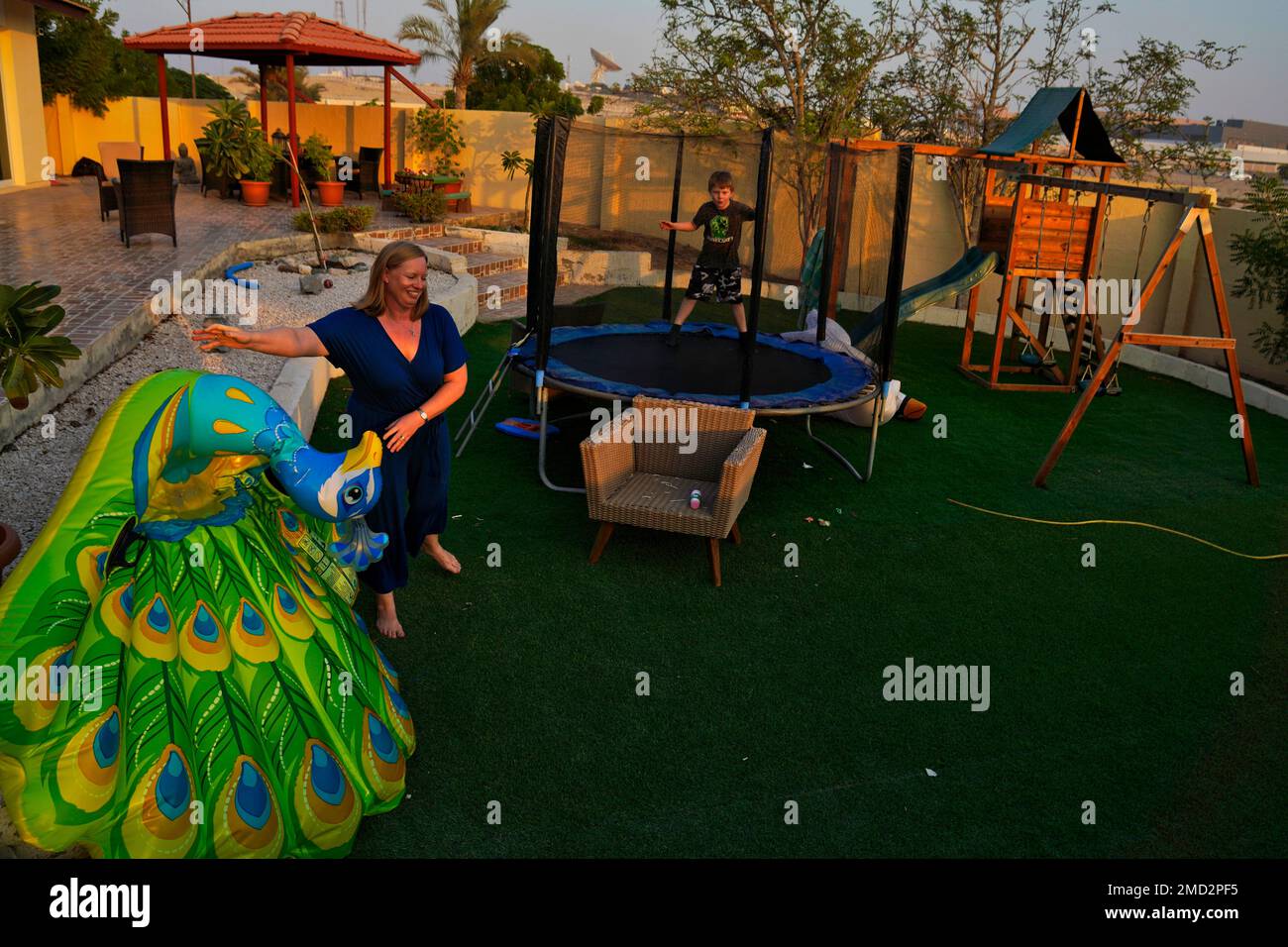 Donna Dickinson moves a peacock pool float as her 7-year-old son Elliot ...
