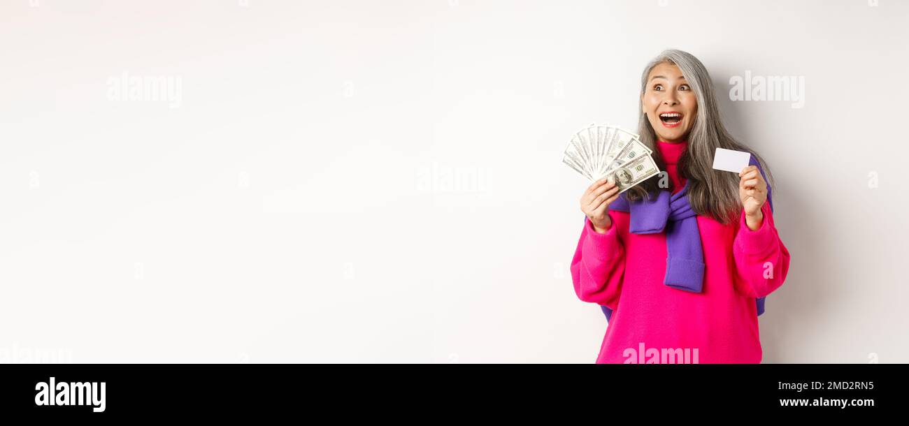 Shopping concept. Happy asian old woman with grey hair, looking ...