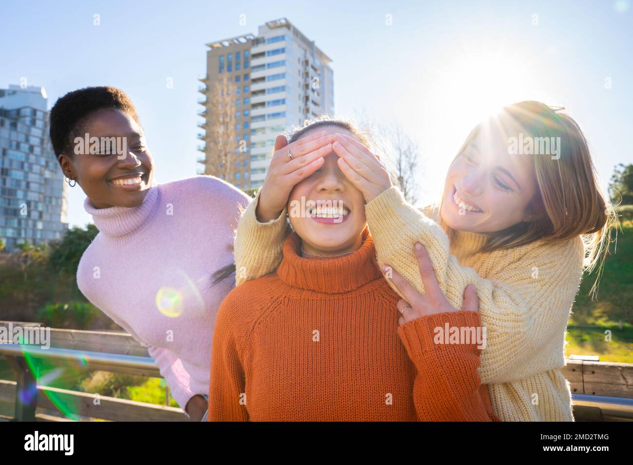 Female friends covering each other eyes for a surprise. Girls having ...