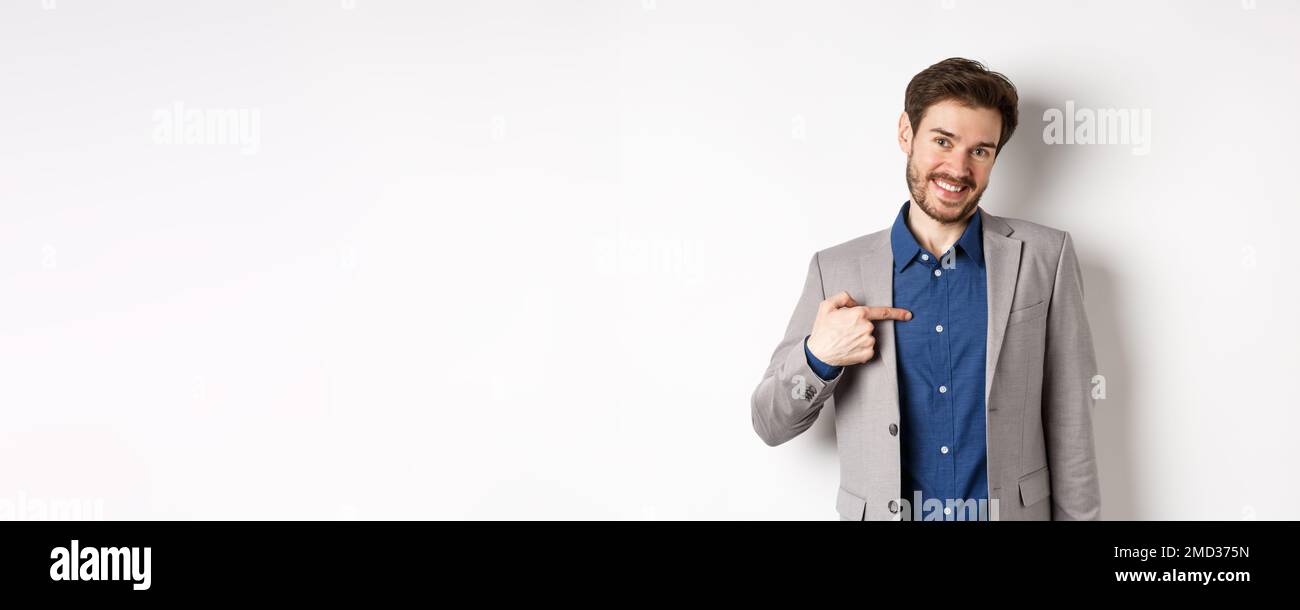 Modest smiling man in suit pointing at himself with cute face, self ...
