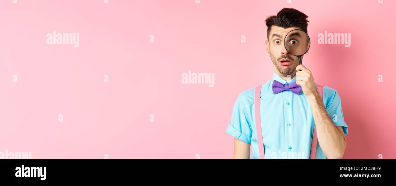Funny guy look through magnifying glass with surprised face, seeing ...