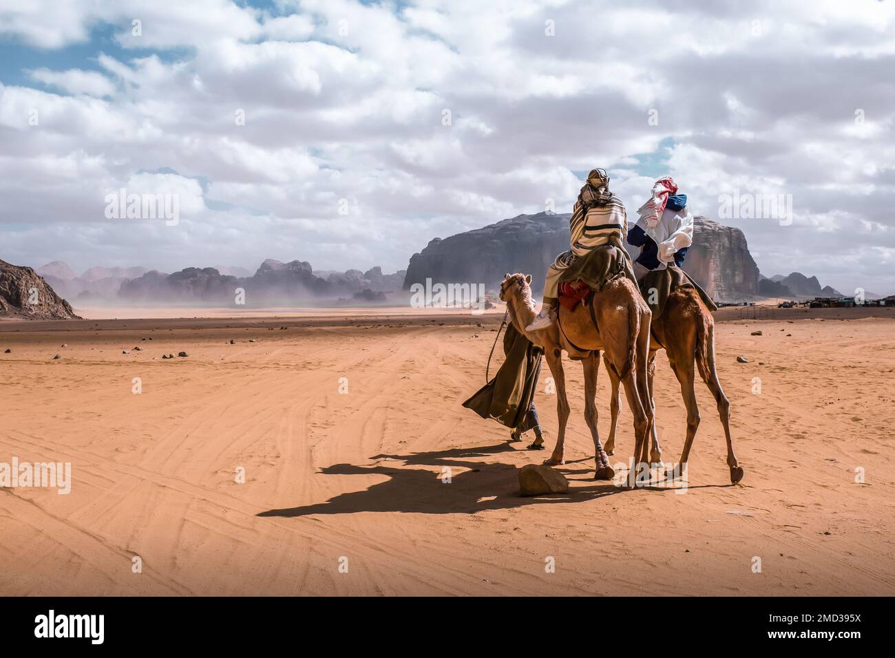 Tourists enjoying a camel ride through the Wadi Rum desert in Jordan ...