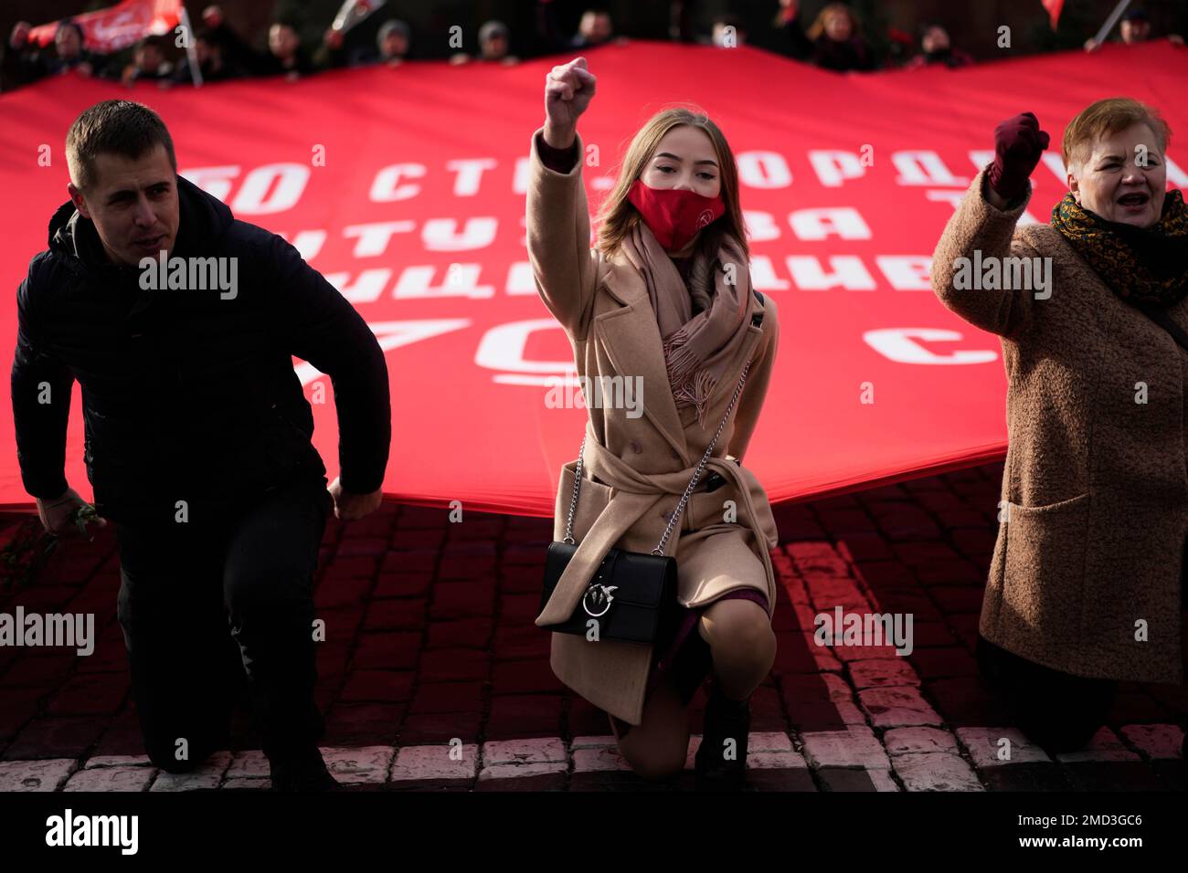 Communist party supporters gesture as they hold a huge red flag near ...