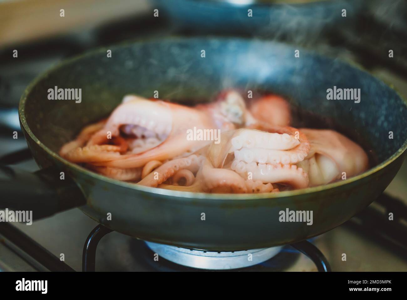 Cooking small octopuses in frying pan Stock Photo - Alamy