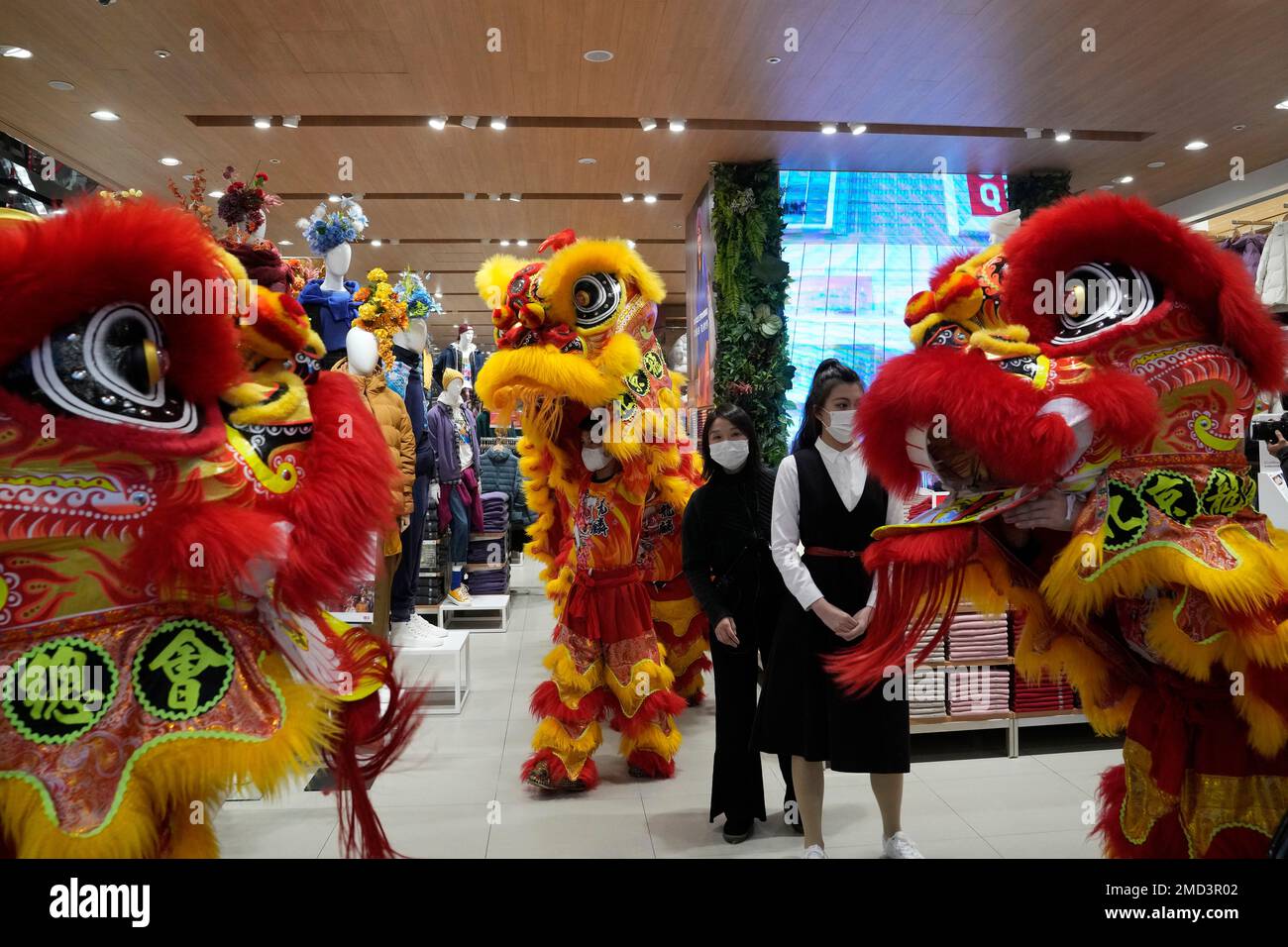 Lion dance performers prepare to welcome customers at the opening of ...