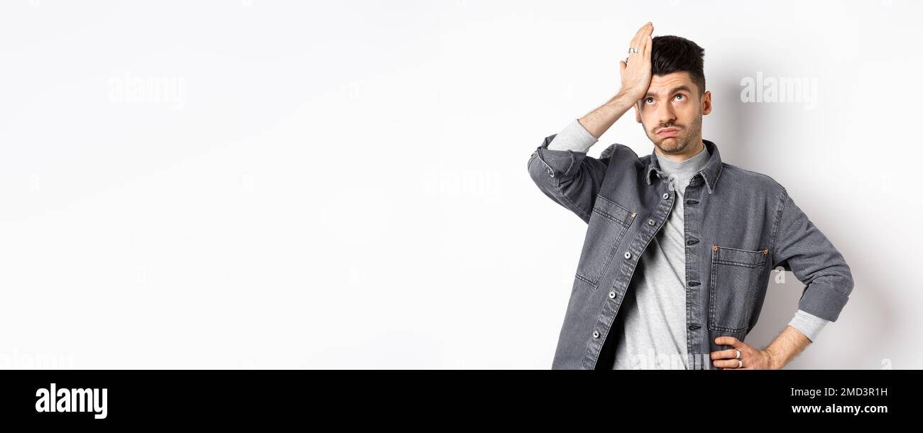 Annoyed young man looking tired or bothered, roll eyes and slap ...