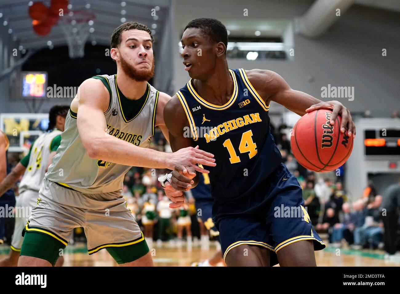 Michigan forward Moussa Diabate (14) drives on Wayne State center Cadin Augustine (21) during ...