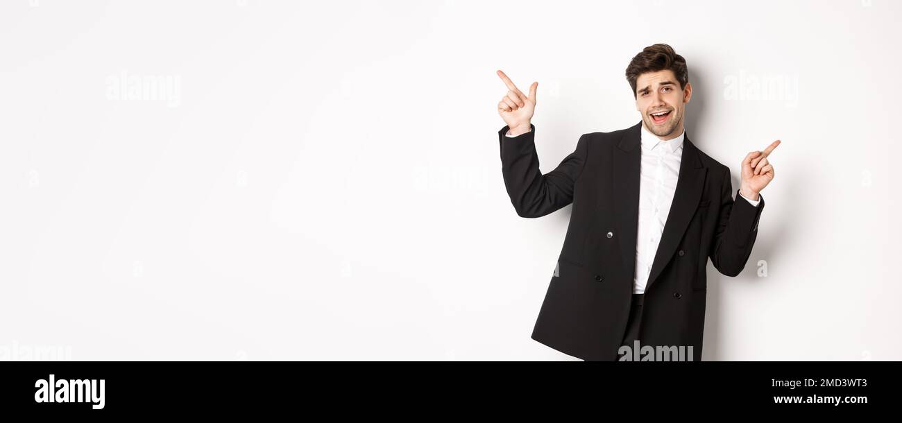 Handsome guy dancing and partying in black suit, pointing fingers ...